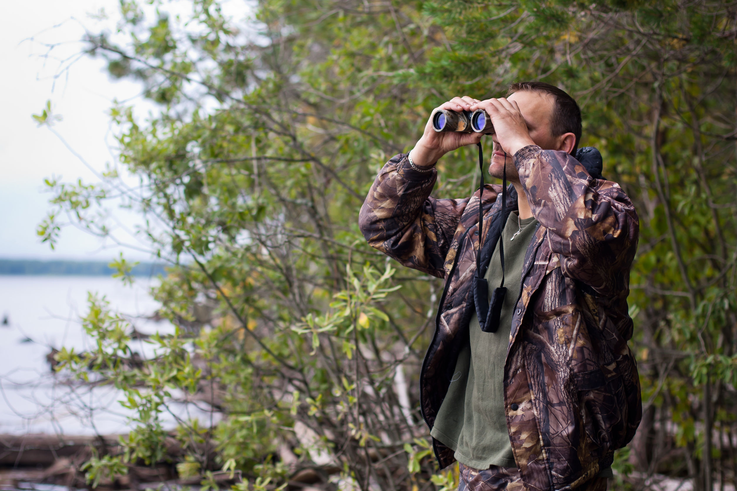 34841647 – hunter looking through binoculars on the river | Get Outdoors PA